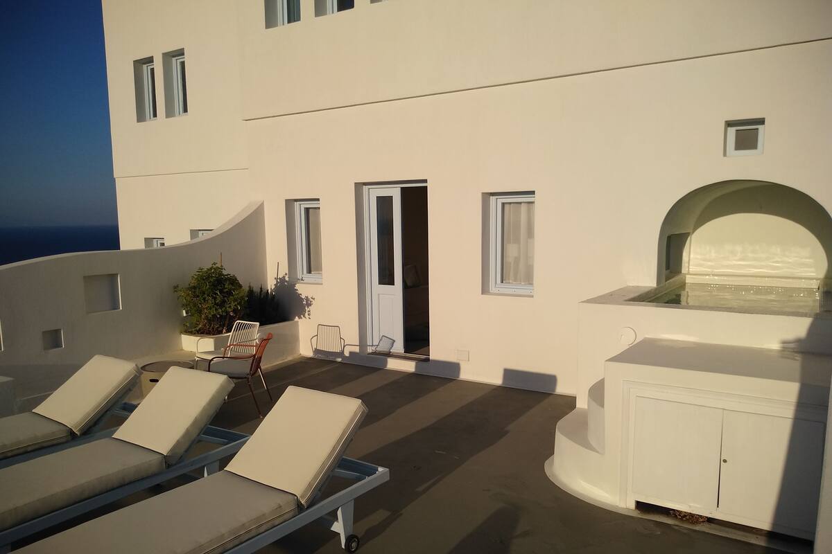 Terraço no telhado com espreguiçadeiras, um espaço de estar pequeno e um recurso de água.
