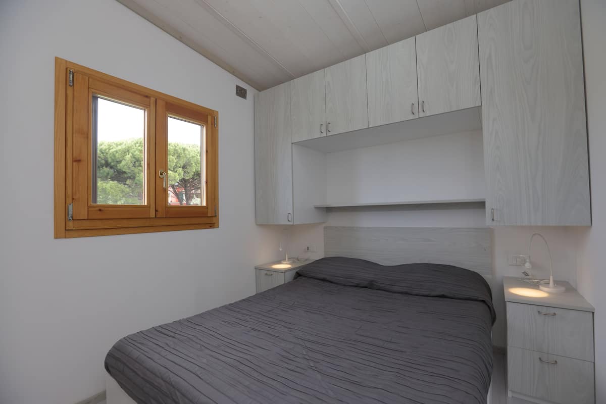 Quarto com cama, janela e armários embutidos.