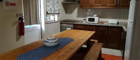 Um frigorífico/congelador grande, um micro-ondas, um forno