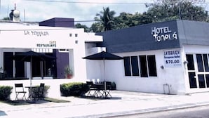 Um edifício com um café chamado 'La Terrazza' e um letreiro do 'Hotel Tonalpa' anunciando 'Desayunos Ballet' por $70,00.