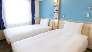 Quarto de hotel com duas camas, janela com cortinas, relógio fixado na parede e prateleira com amenidades.
