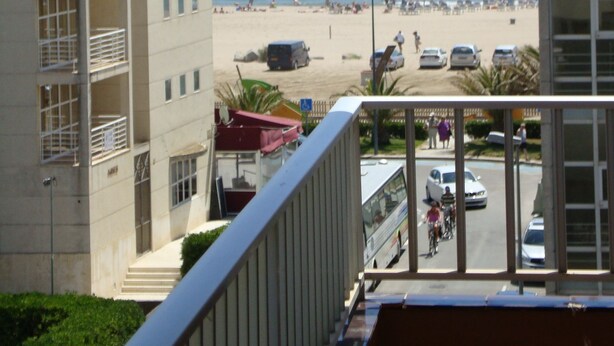 Vista de uma praia, com um edifício em primeiro plano.