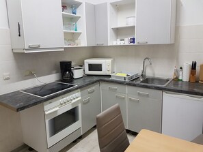 Um frigorífico, um micro-ondas, um forno, uma placa de cozinha 