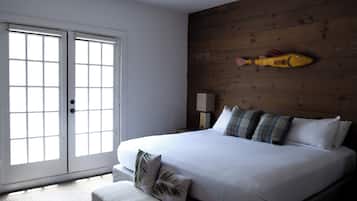Quarto com uma cama grande, um banco, parede de madeira e uma decoração de peixe.