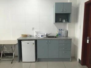Um frigorífico, uma cafeteira/bule, uma chaleira elétrica 