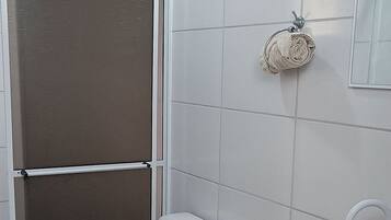 Apartamento básico | Banheiro | Chuveiro, chuveiro com efeito de chuva, toalhas de banho