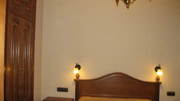 Quarto com cabeceira de madeira, duas luminárias de cabeceira, mesa de cabeceira e guarda-roupa.