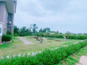 Um jardim com um caminho pavimentado, mobiliário de exterior e um gazebo.