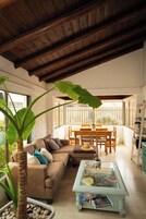 Uma sala de estar com sofá, mesa de centro e um espaço de jantar com cadeiras e uma mesa.