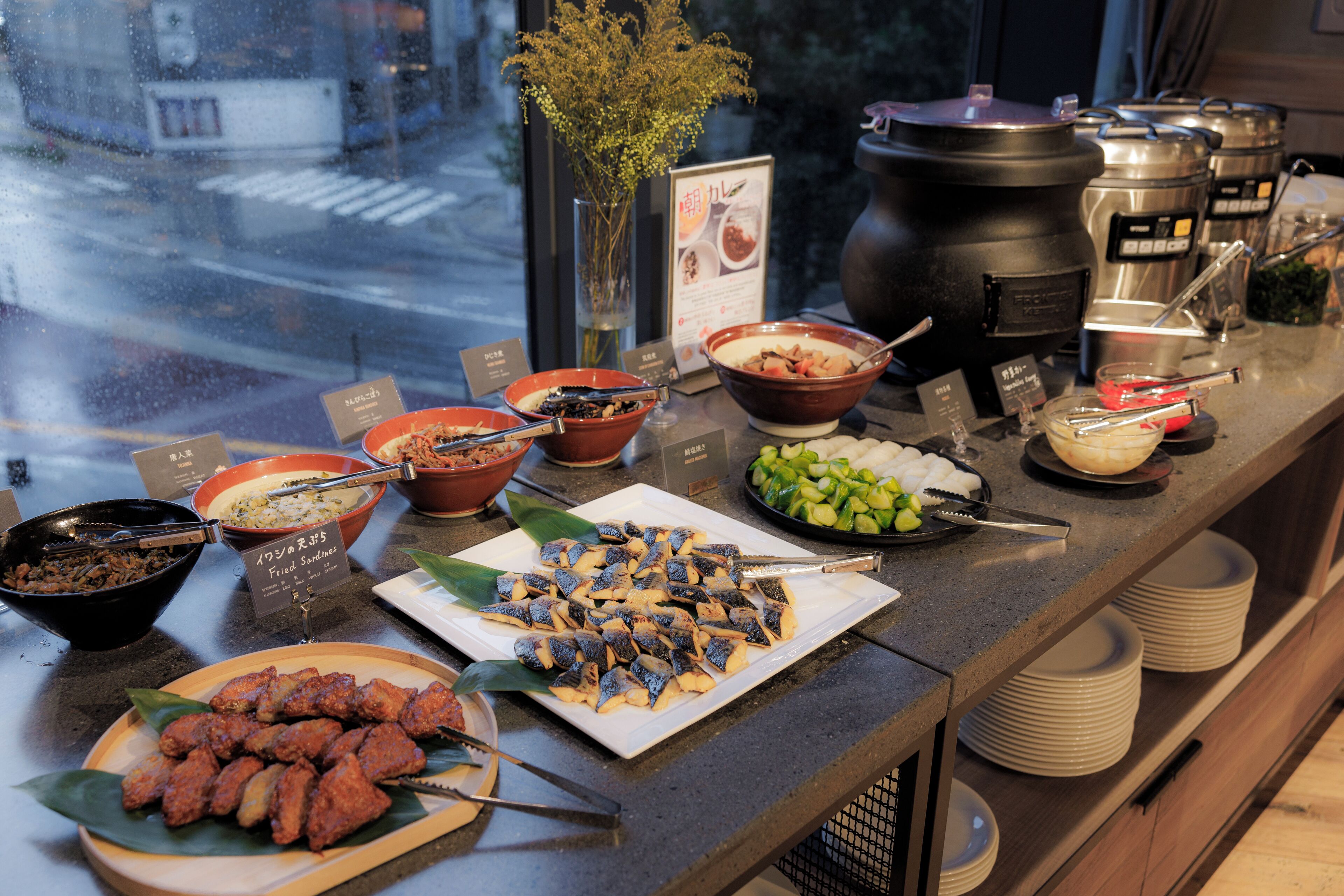 Buffet com diversos pratos e utensílios, incluindo frutos do mar fritos, saladas e sopa.