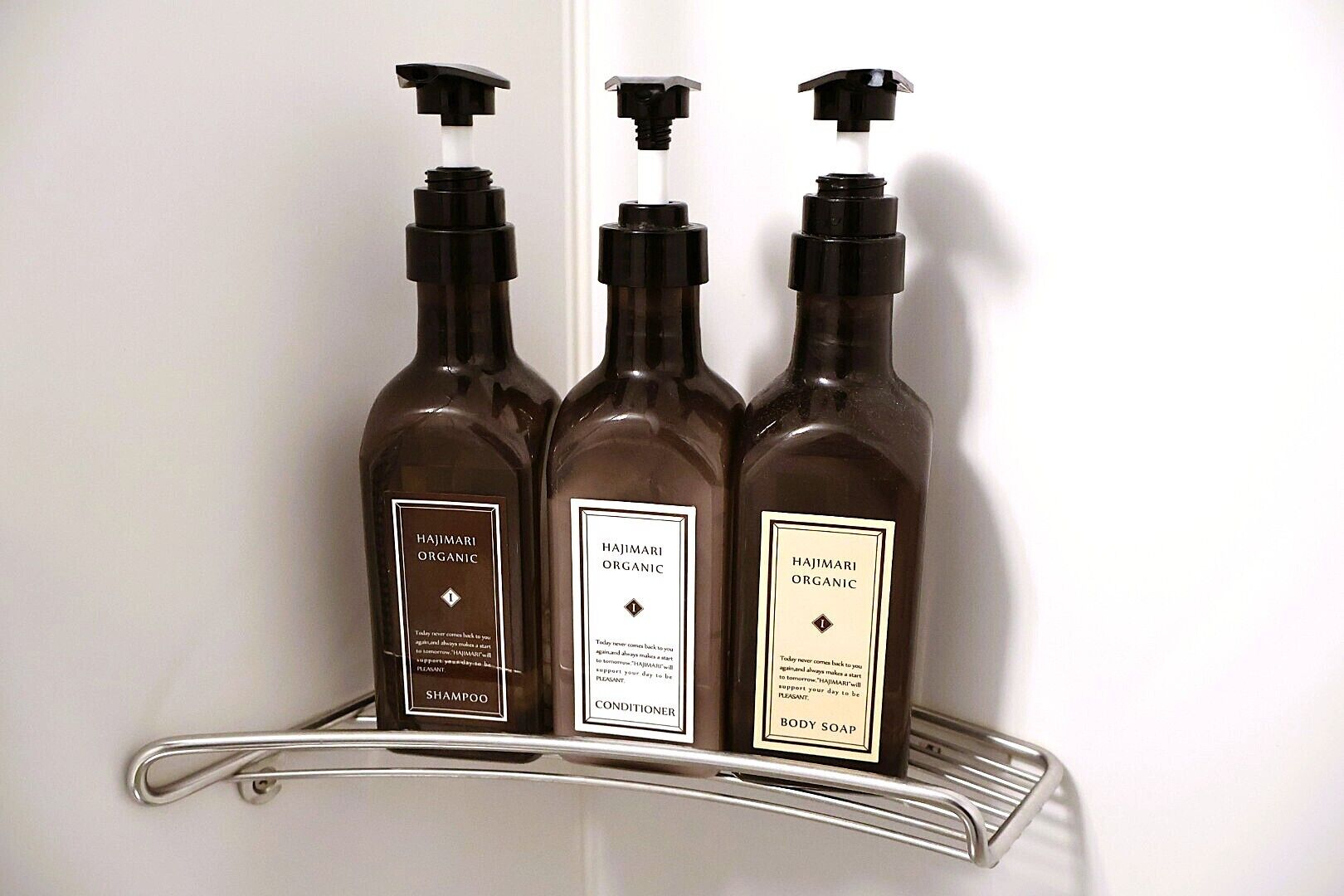Três frascos de produtos orgânicos Hajimari sobre uma prateleira de metal.