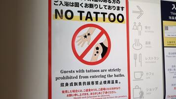 Um aviso proíbe tatuagens nos banheiros.