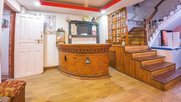 Uma sala de estar espaçosa com escada de madeira, lareira de tijolos e porta branca.