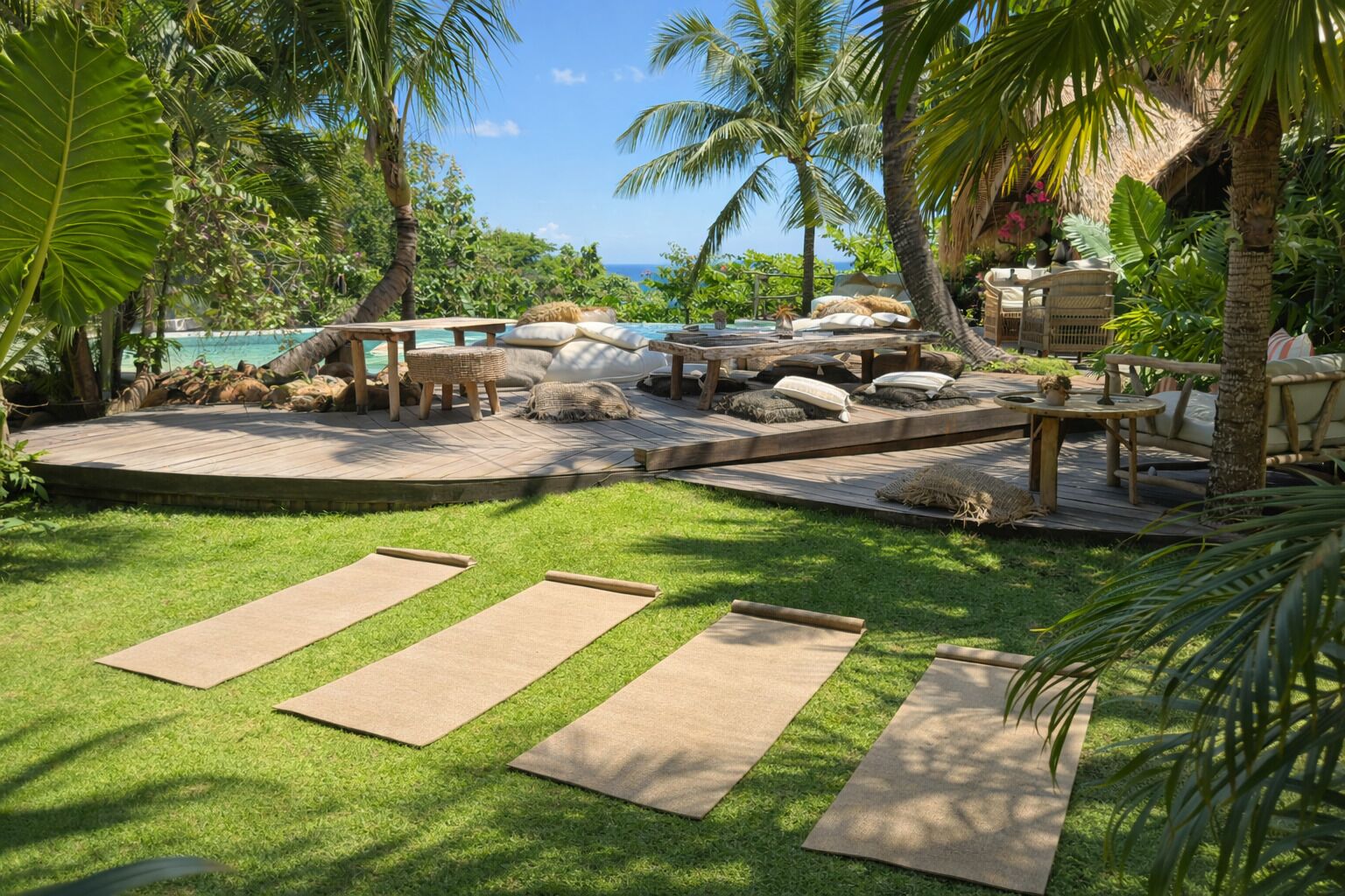 Uma área tropical ao ar livre com piscina, espreguiçadeiras e um deck de madeira.