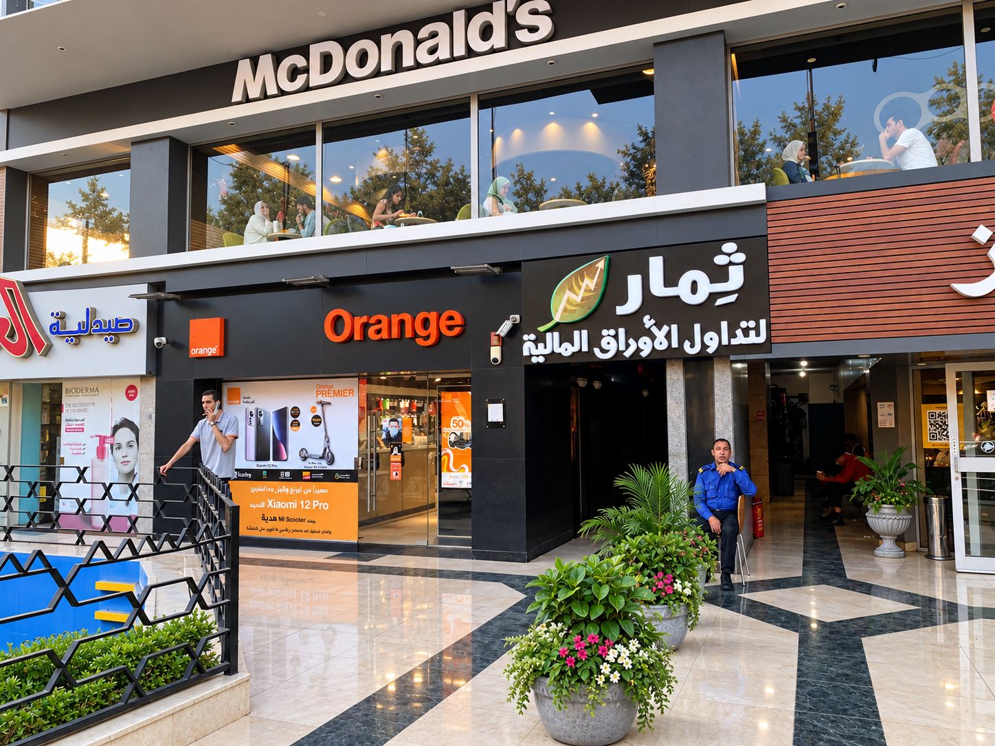 Um centro comercial com um McDonald's, uma loja Orange e uma farmácia.