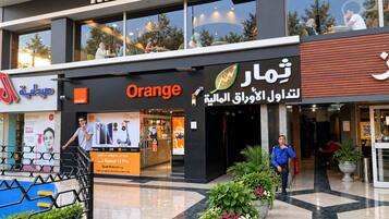 Um centro comercial com um McDonald's, uma loja Orange e uma farmácia.