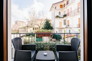 Varanda com mobiliário de vime e vista para uma área residencial.