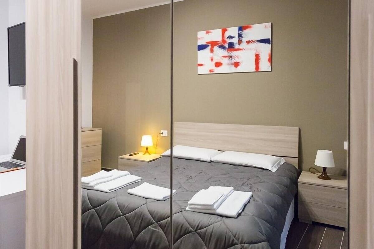 Um quarto moderno com uma cama grande, uma escrivaninha e uma cadeira.