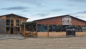 Um restaurante com fachada de tijolos, grandes janelas e exterior de madeira.