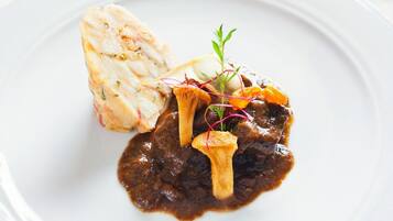 Um prato com carne, cogumelos e uma porção de pão.