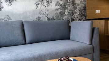 Apartamento Deluxe, 1 cama king-size e sofá-cama, vista para o pátio | Sala de estar | TV de ecrã plano