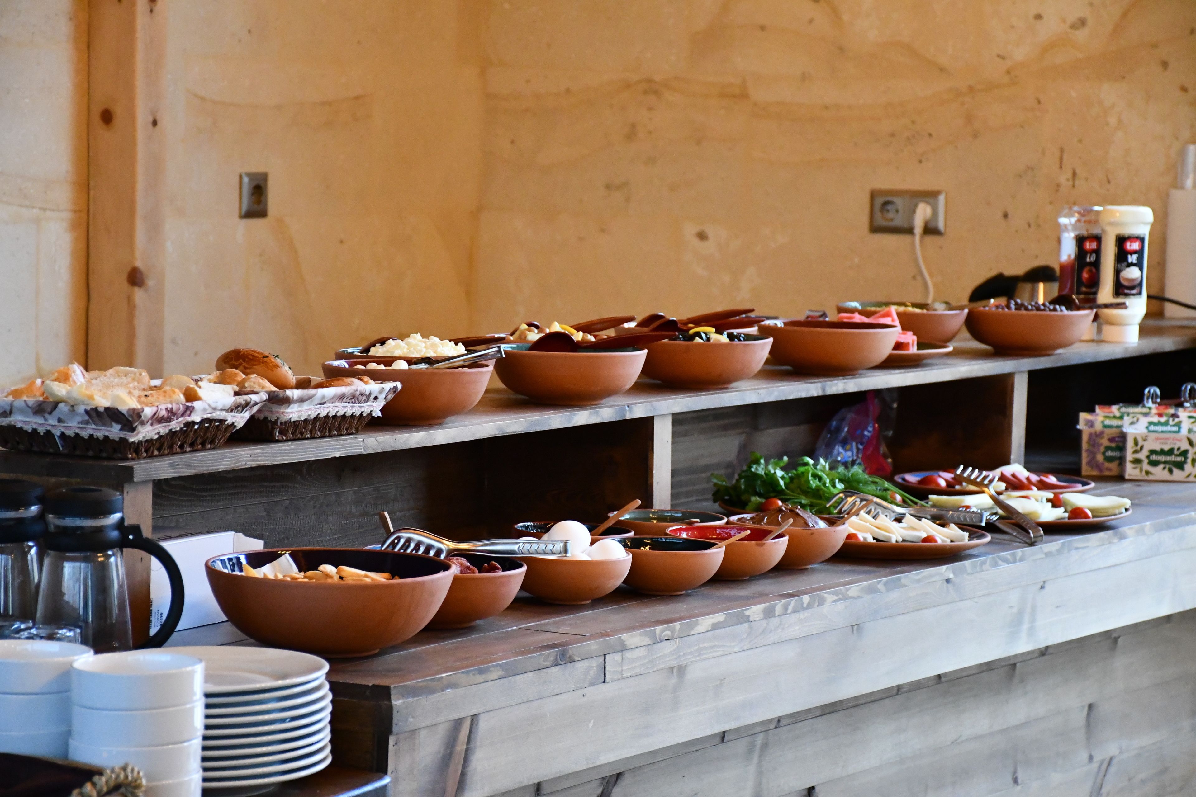 Uma mesa de buffet com diversos alimentos e utensílios para servir.