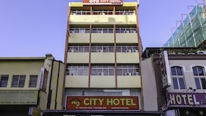 Um edifício de vários andares com uma placa indicando "OYO CITY HOTEL" no topo.