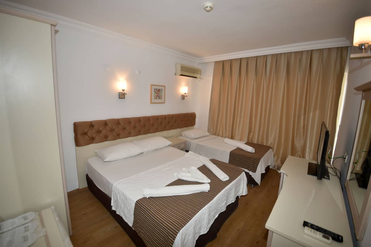 Quarto de hotel com duas camas, uma escrivaninha, uma televisão e um espelho.