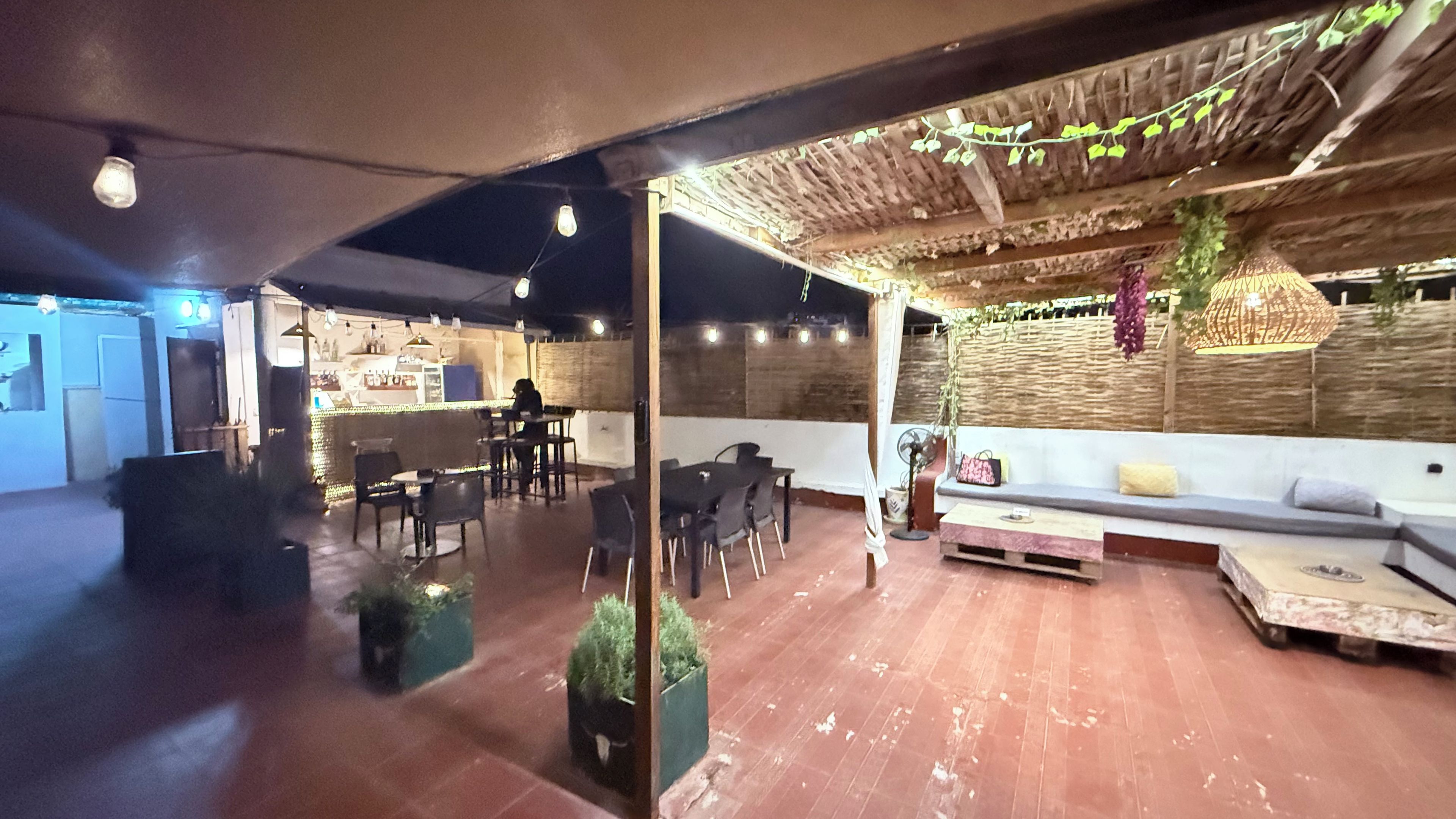 Um espaço interno com área de estar, mesas e um bar.