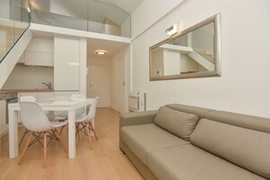 Um interior moderno com uma área de refeições, um sofá e uma escada.