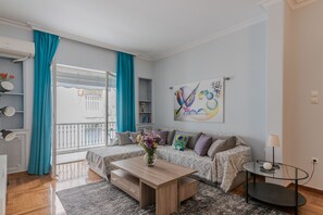 Uma sala de estar moderna com sofá, mesa de centro e obras de arte na parede.