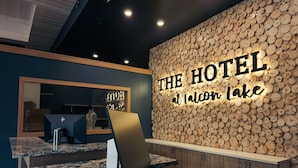 Uma receção com um painel de parede de madeira e um letreiro com a inscrição "The Hotel at Falcon Lake".