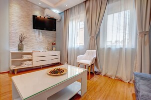 Quarto duplo conforto, 1 cama de casal e sofá-cama, vista para o jardim | Área de estar | TV de tela plana