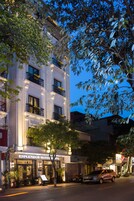 Um hotel com fachada clássica, várias varandas e entrada bem iluminada.