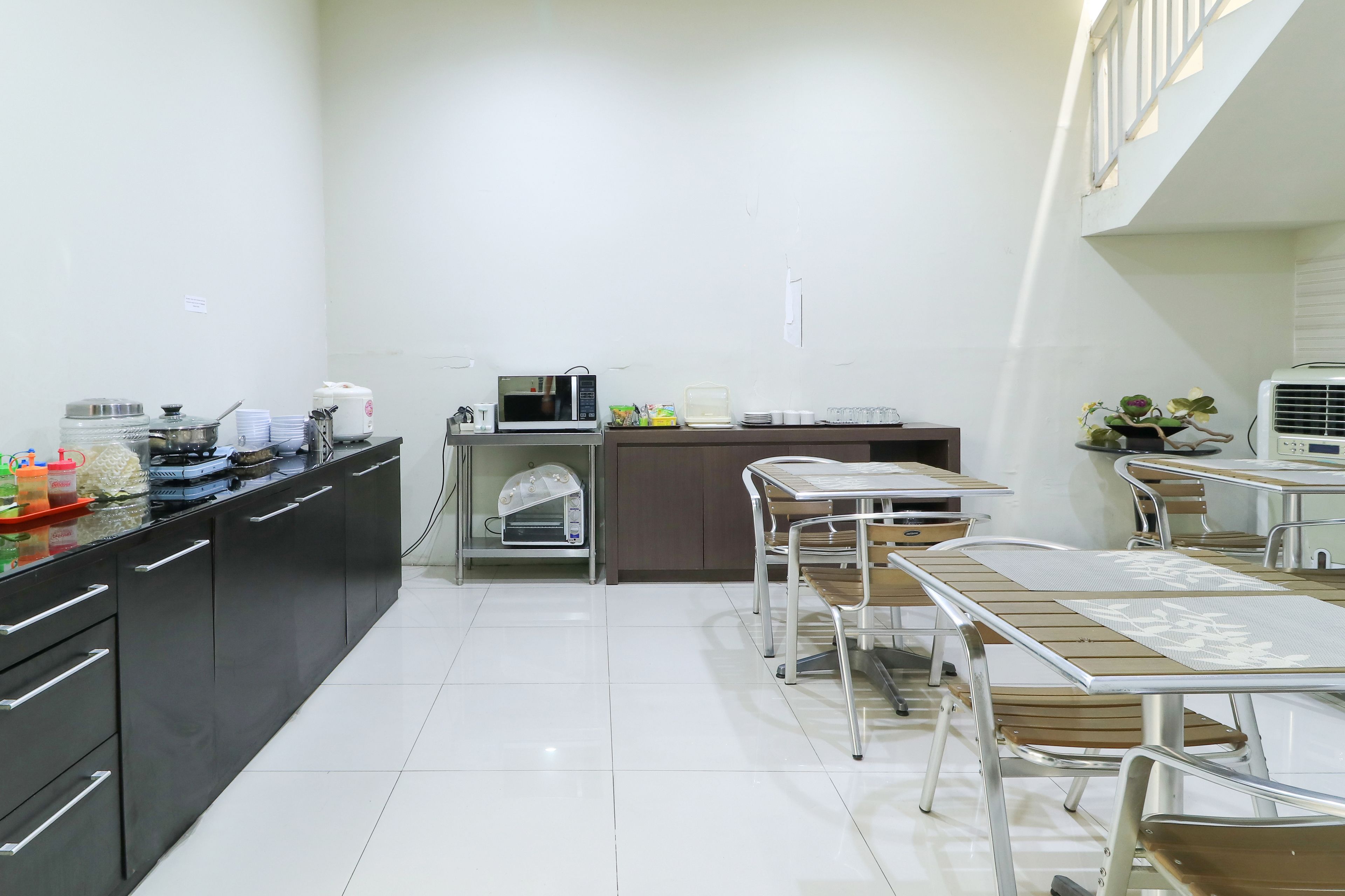 Cozinha moderna com área de jantar, equipada com micro-ondas, torradeira e diversos eletrodomésticos.