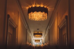 Um corredor imponente com um grande candelabro ornamentado e design simétrico.