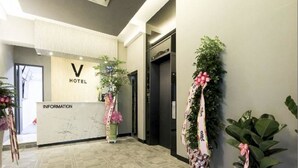 Uma área de recepção de hotel com um balcão de recepção rotulado com 
