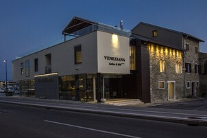 Um edifício moderno com uma placa que diz 'Veneziana Suites & SPA'.