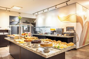 Um buffet com diversos doces e itens de café da manhã.