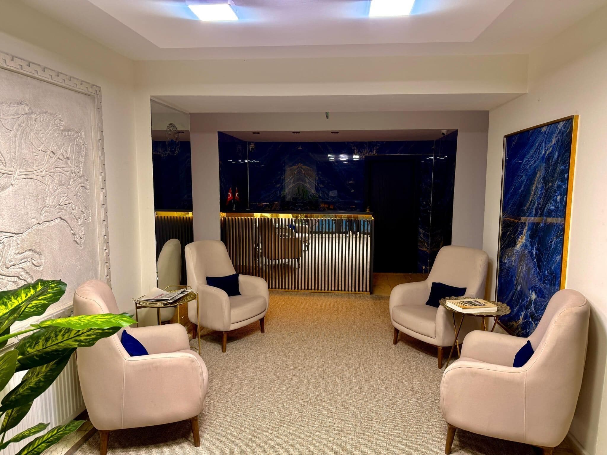 Um lounge moderno com assentos confortáveis, um balcão de recepção e uma grande pintura abstrata.