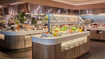 Disposição moderna de buffet com diversas estações de serviço, uma variedade de alimentos e design limpo e contemporâneo.