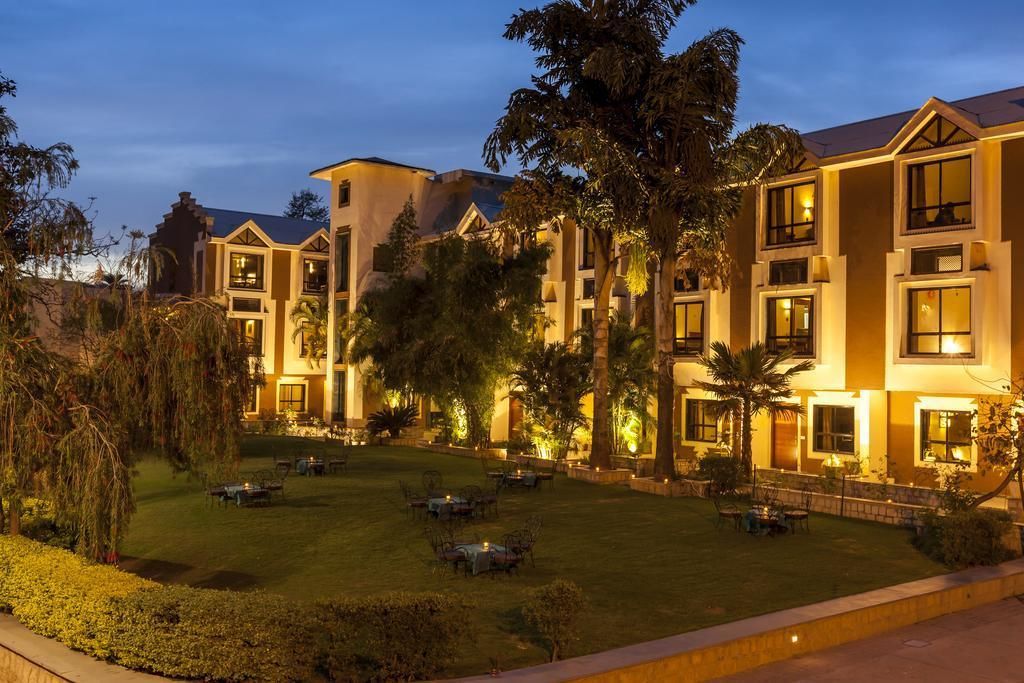 Um hotel com vários edifícios, um gramado bem cuidado e áreas de estar ao ar livre.
