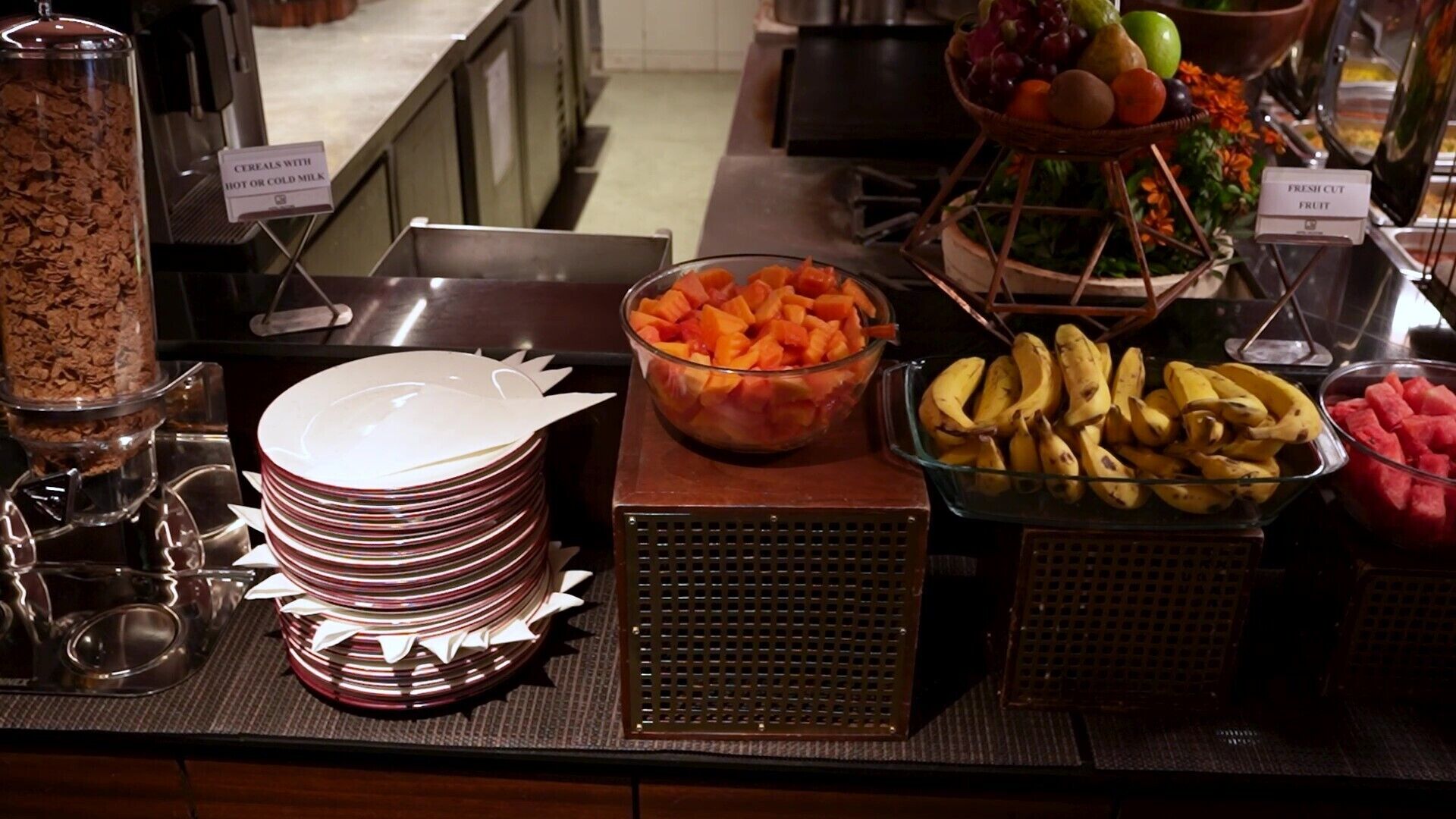 Buffet com diversos alimentos, incluindo frutas, vegetais e cereais.