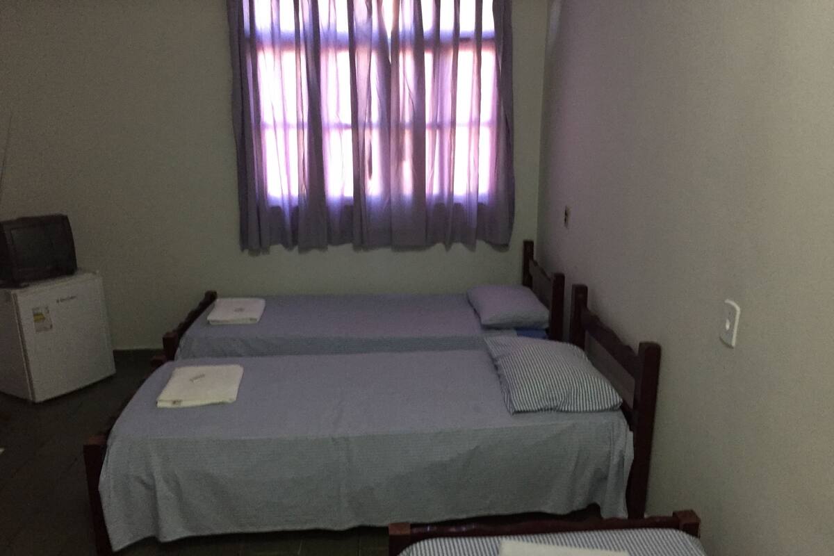 Quarto triplo urbano, 3 camas de solteiro | Escrivaninha, cortinas blackout, roupa de cama