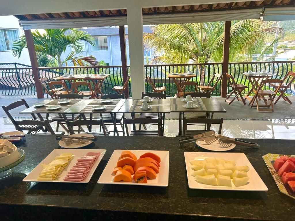 Disposição de buffet com diversos tipos de comida, mesas e cadeiras.