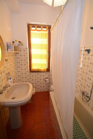 Uma casa de banho com lavatório, sanita e banheira.