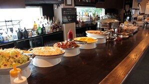 Um balcão de buffet com diversos pratos e acompanhamentos.