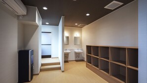 Um corredor com geladeira, escada e prateleiras.