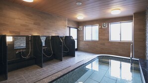 Uma área interna de piscina moderna, com piso ladrilhado, piscina com água cristalina e paredes de madeira.