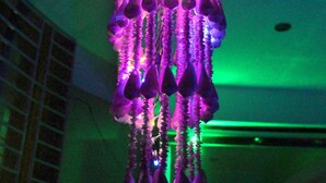 Um candelabro com vários níveis de enfeites e luzes pendurados.